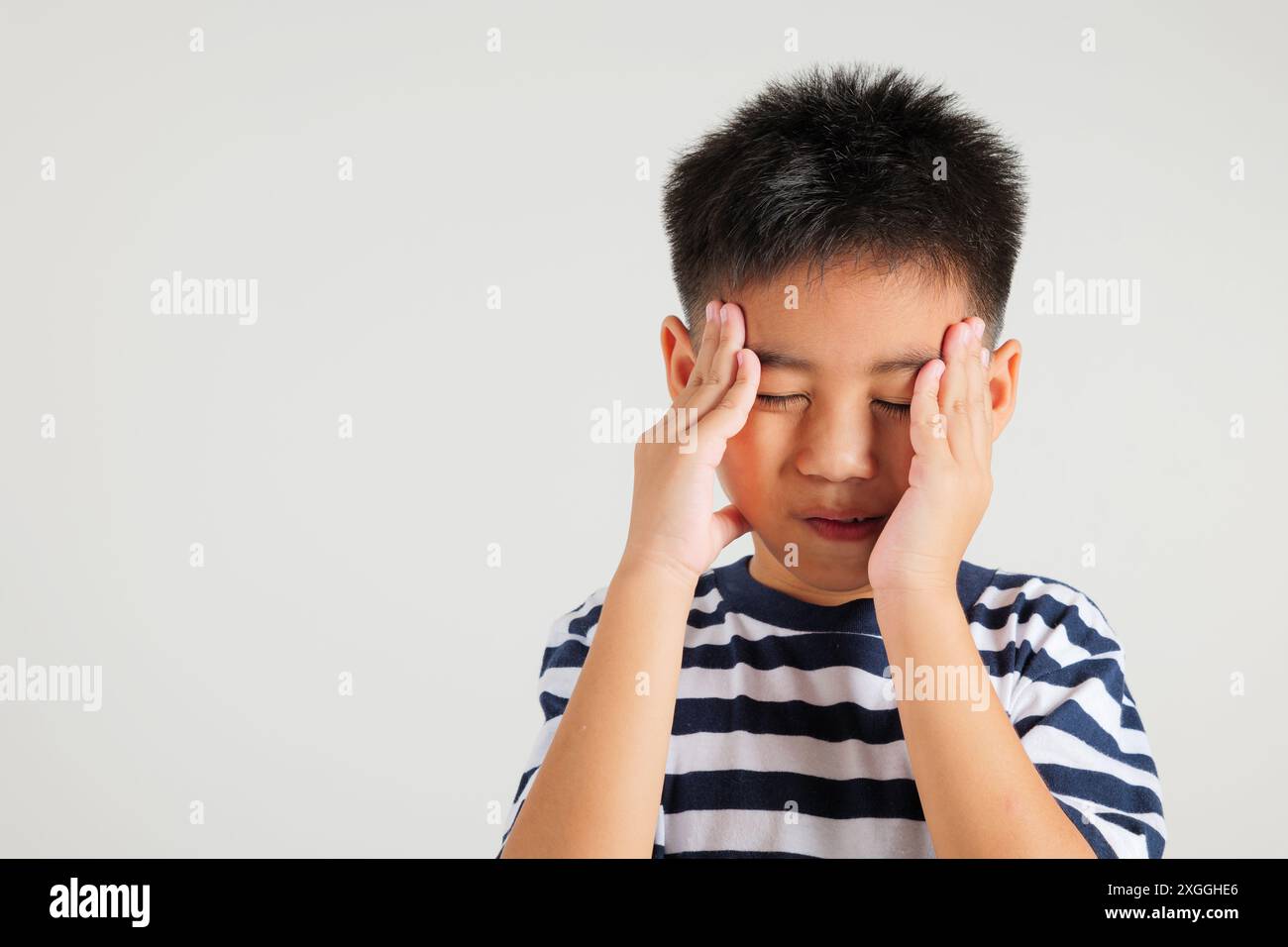 Portrait of Asian young kid boy sad tired strain face holding hold head ...