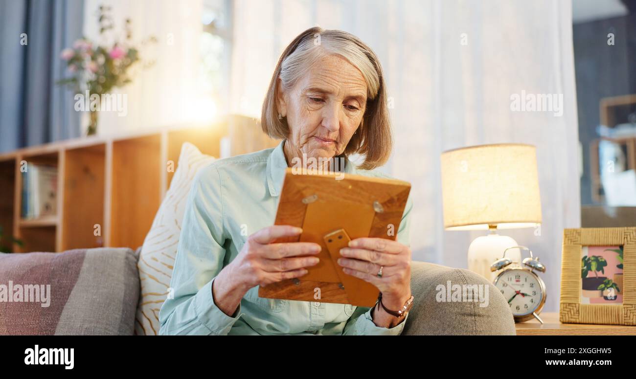 Sad, senior woman and picture frame for memory, nostalgia and remember history in home living ...