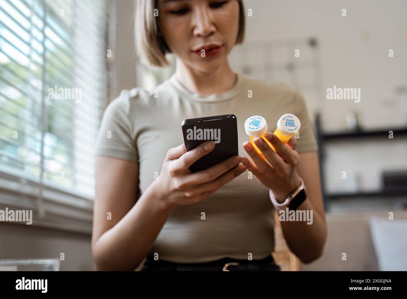 Woman Checking Medication Information on Smartphone While Holding Pill ...