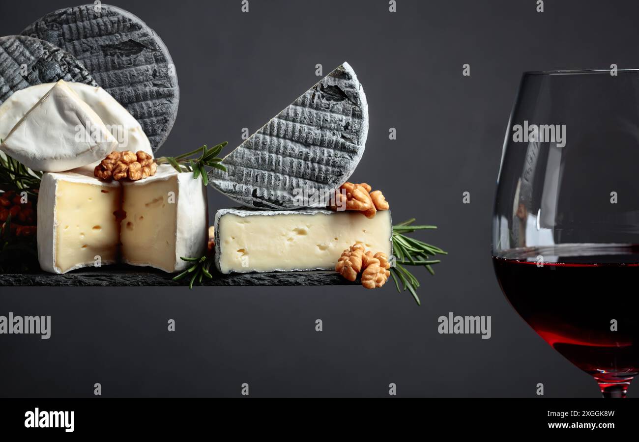 Red wine and soft cheeses with walnuts and rosemary. Copy space Stock ...
