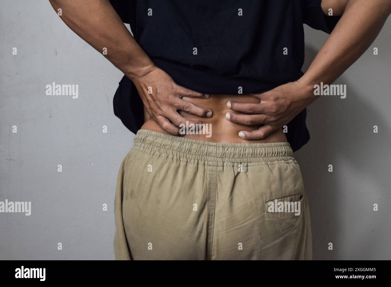 Man's hand he is caught at the waist and his back is painful at the ...