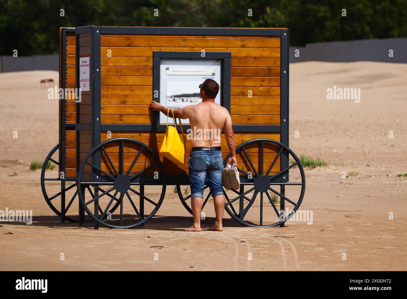 A man stands at a changing booth on one of the beaches of the Gulf of ...