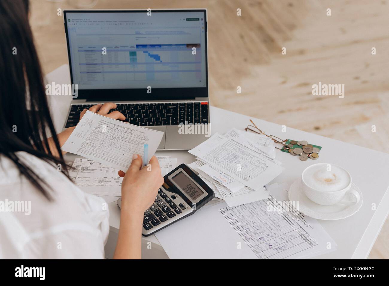 Back view of unrecognizable woman calculates utility expenses on laptop ...