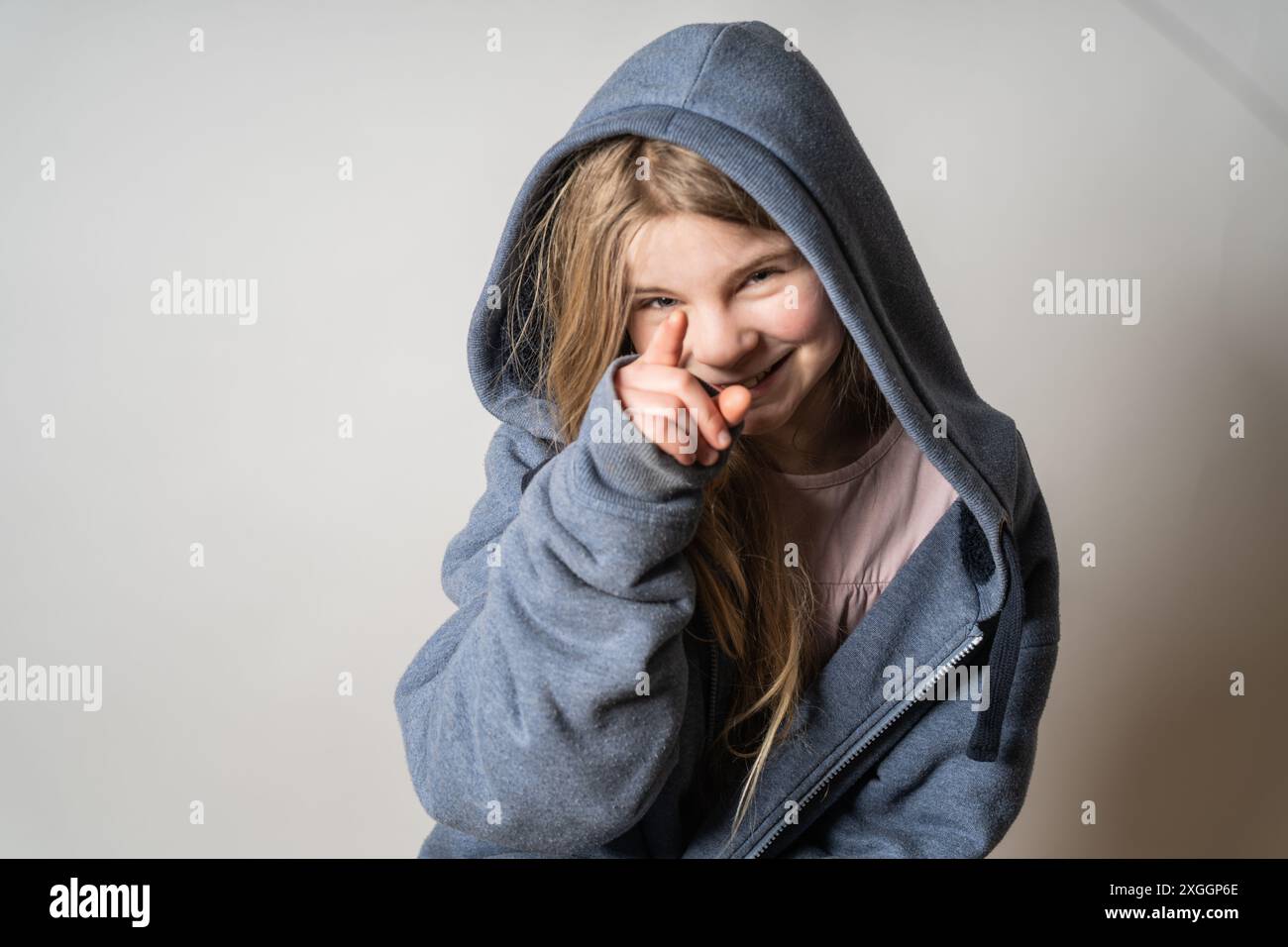 The young girl likes to dance in a gray jacket. Her long, blonde hair ...