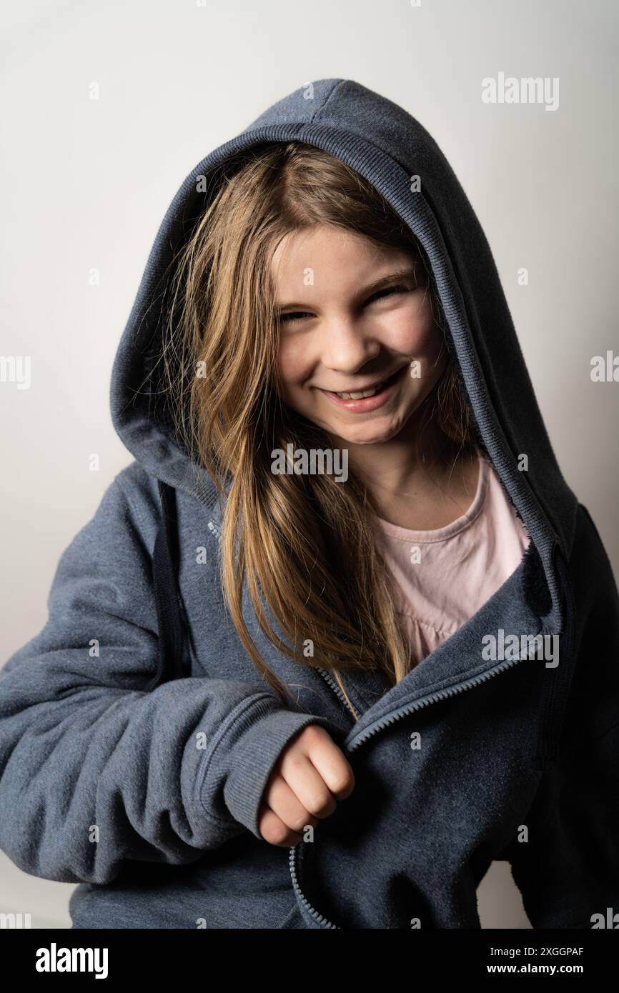 The young girl likes to dance in a gray jacket. Her long, blonde hair ...