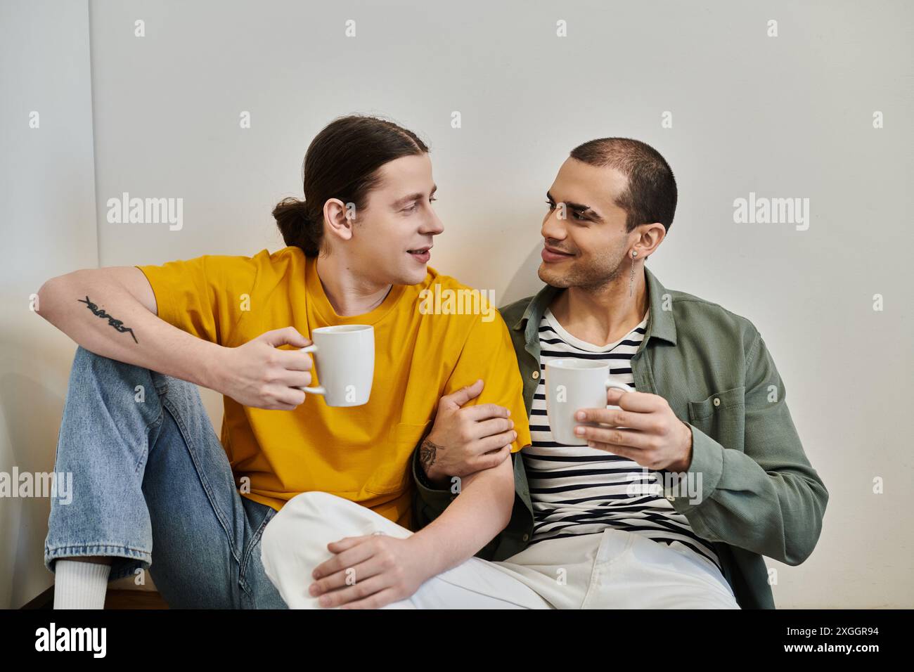 A young gay couple enjoys a relaxing morning together in their ...