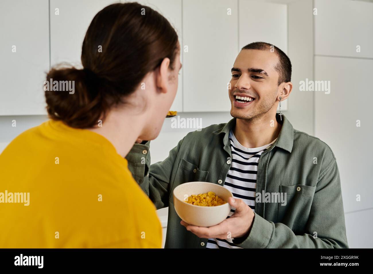 A young gay couple enjoys a casual breakfast together in their modern ...