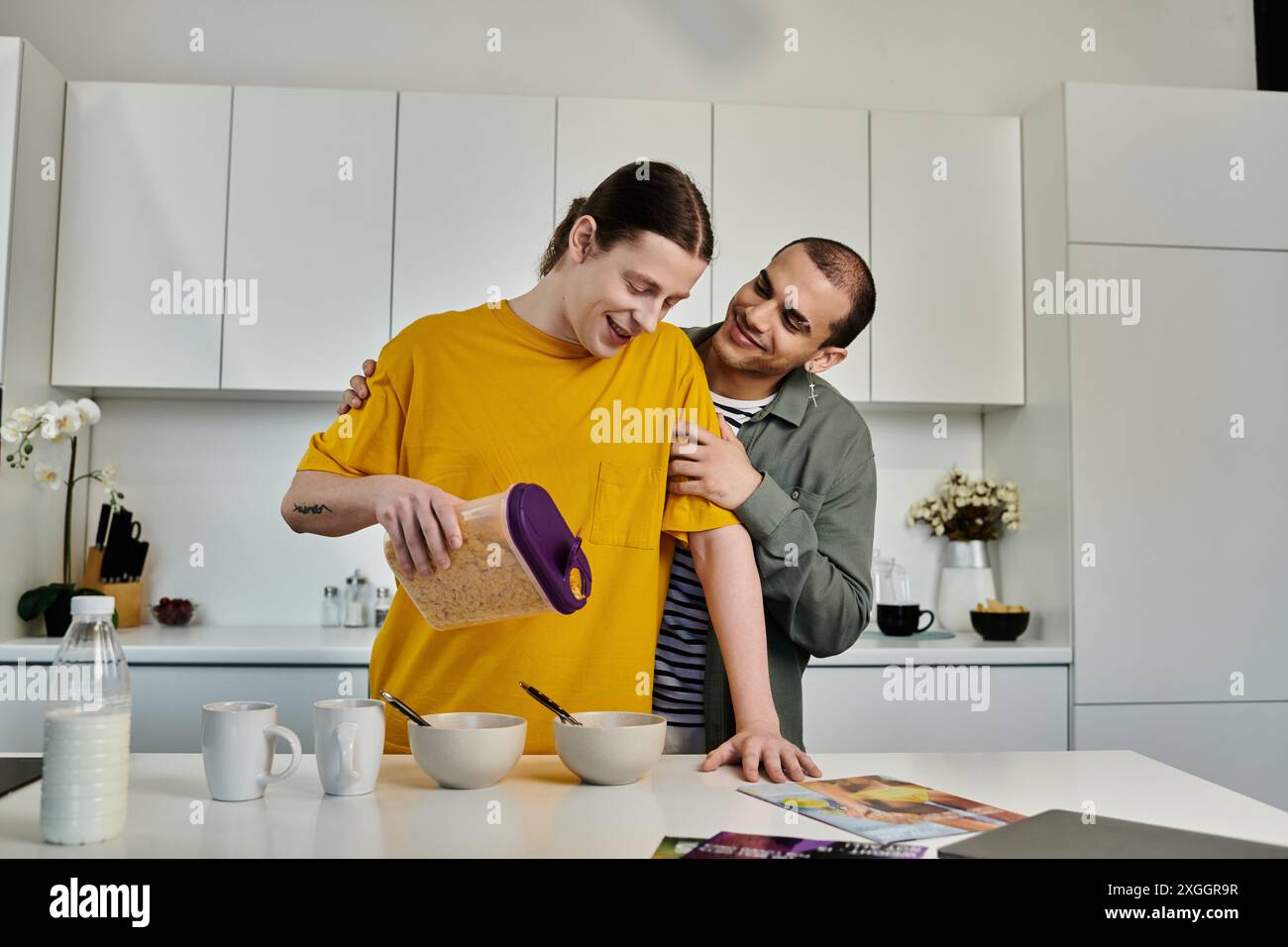 A gay couple shares a tender moment in their kitchen as they prepare ...