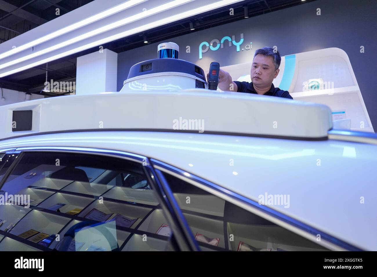 (240709) -- BEIJING, July 9, 2024 (Xinhua) -- Wang Wei checks the sensor of an autonomous ...