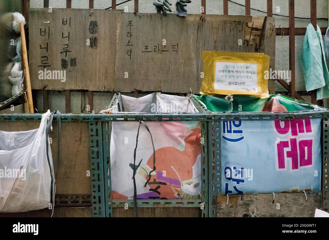 Urban Korean street scene with handwritten signs, recycling bins, and ...