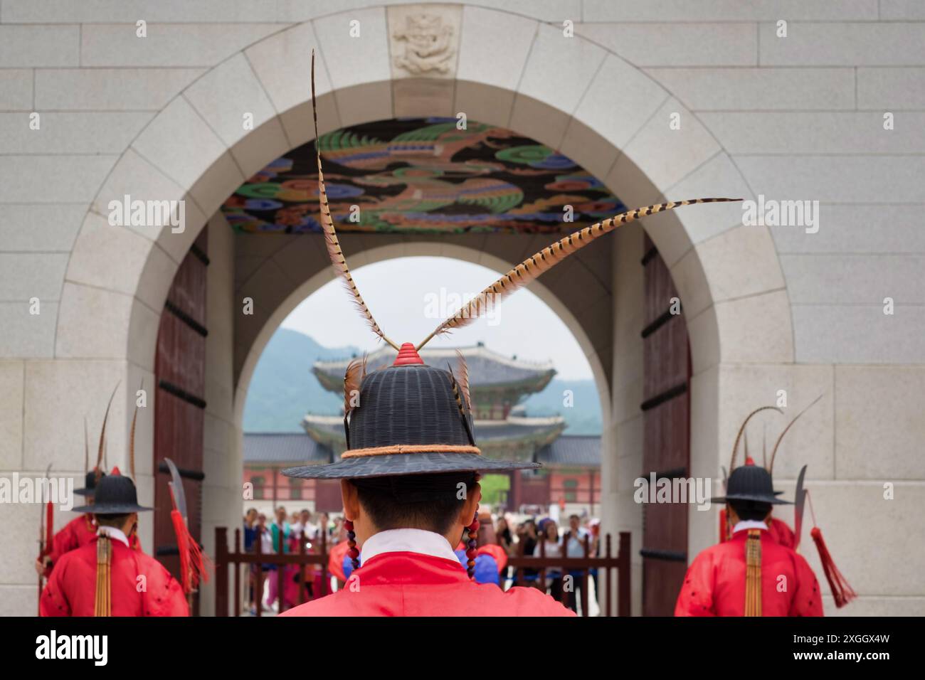 Korean palace guards in traditional red uniforms and ornate hats stand ...