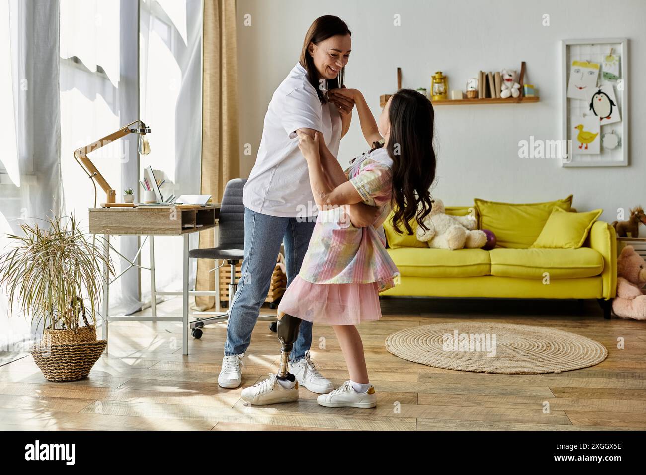 A brunette mother and her daughter with a prosthetic leg are dancing ...