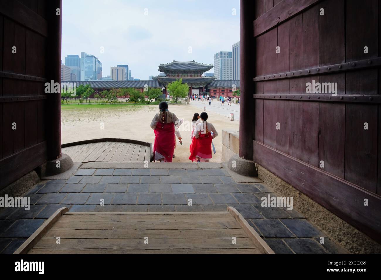 View through traditional Korean palace gate, modern cityscape visible ...