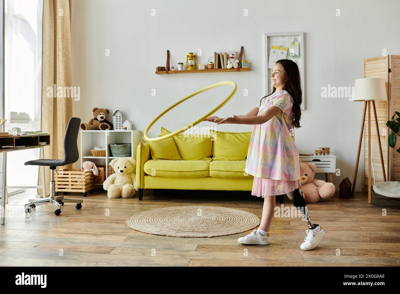 A young girl with a prosthetic leg plays with a hula hoop in her living ...
