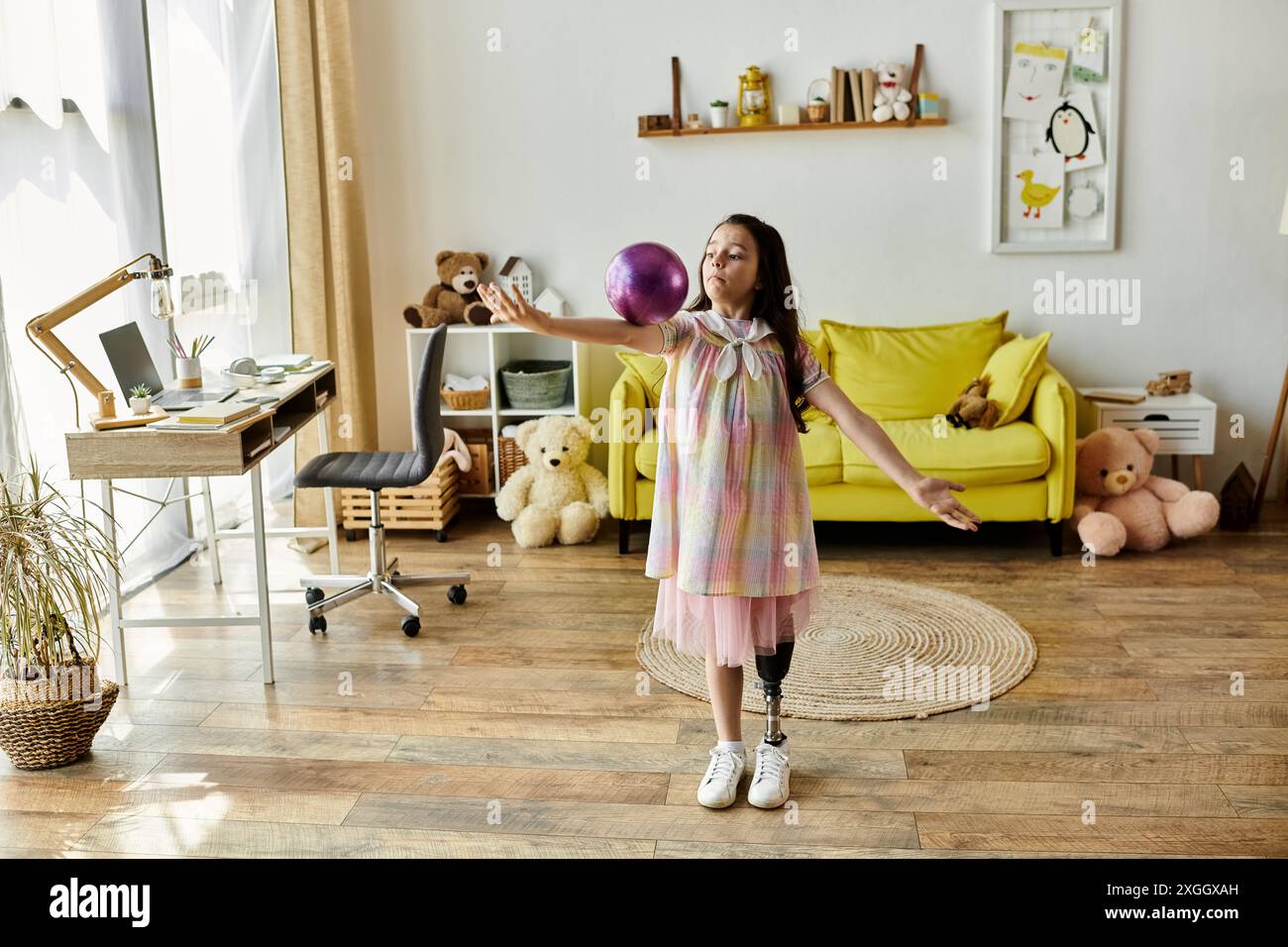 A young girl with a prosthetic leg throws a ball while smiling in her ...