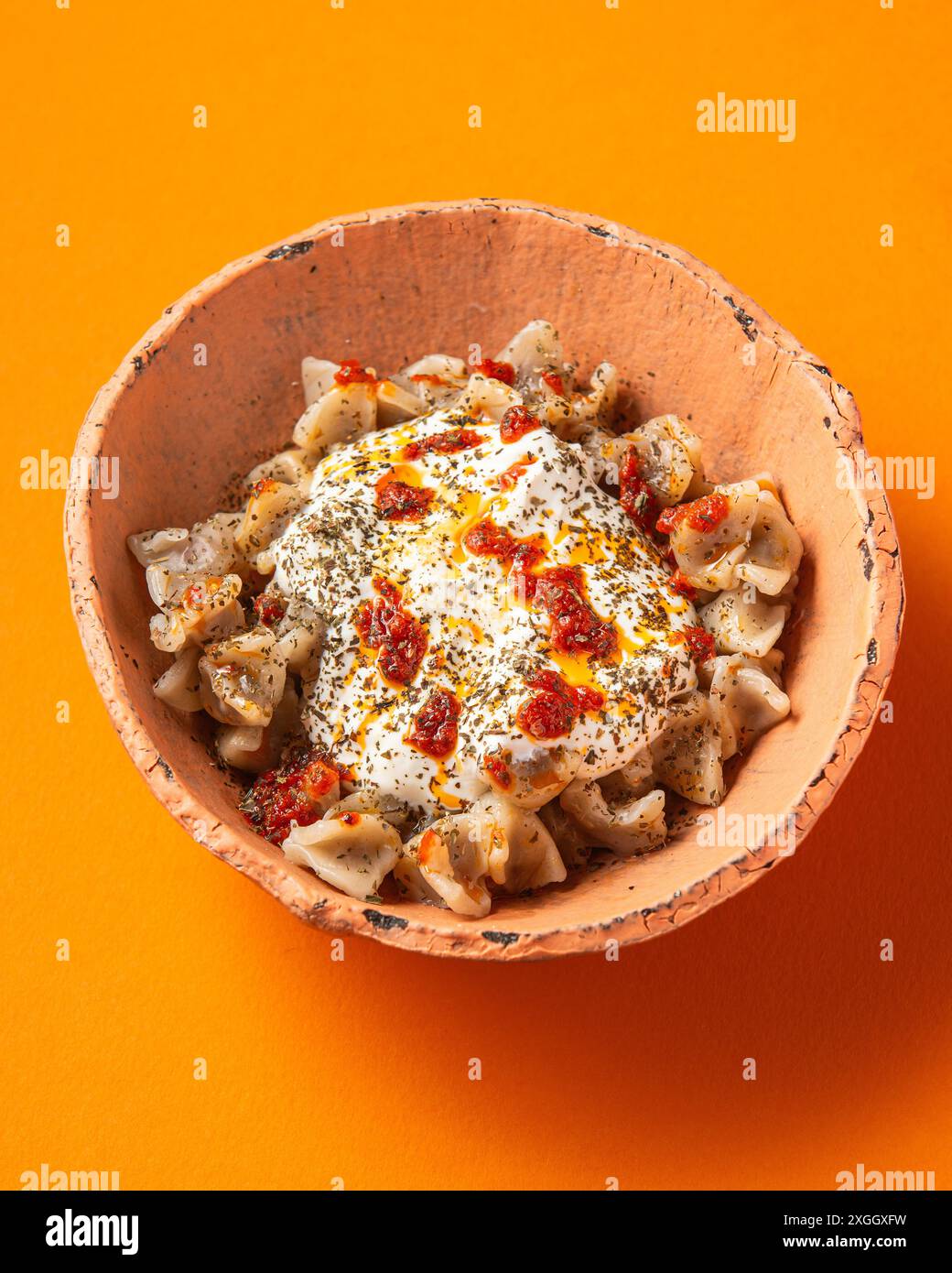 Turkish Dumplings Manti in a bowl on a vibrant background. PInk-orange ...