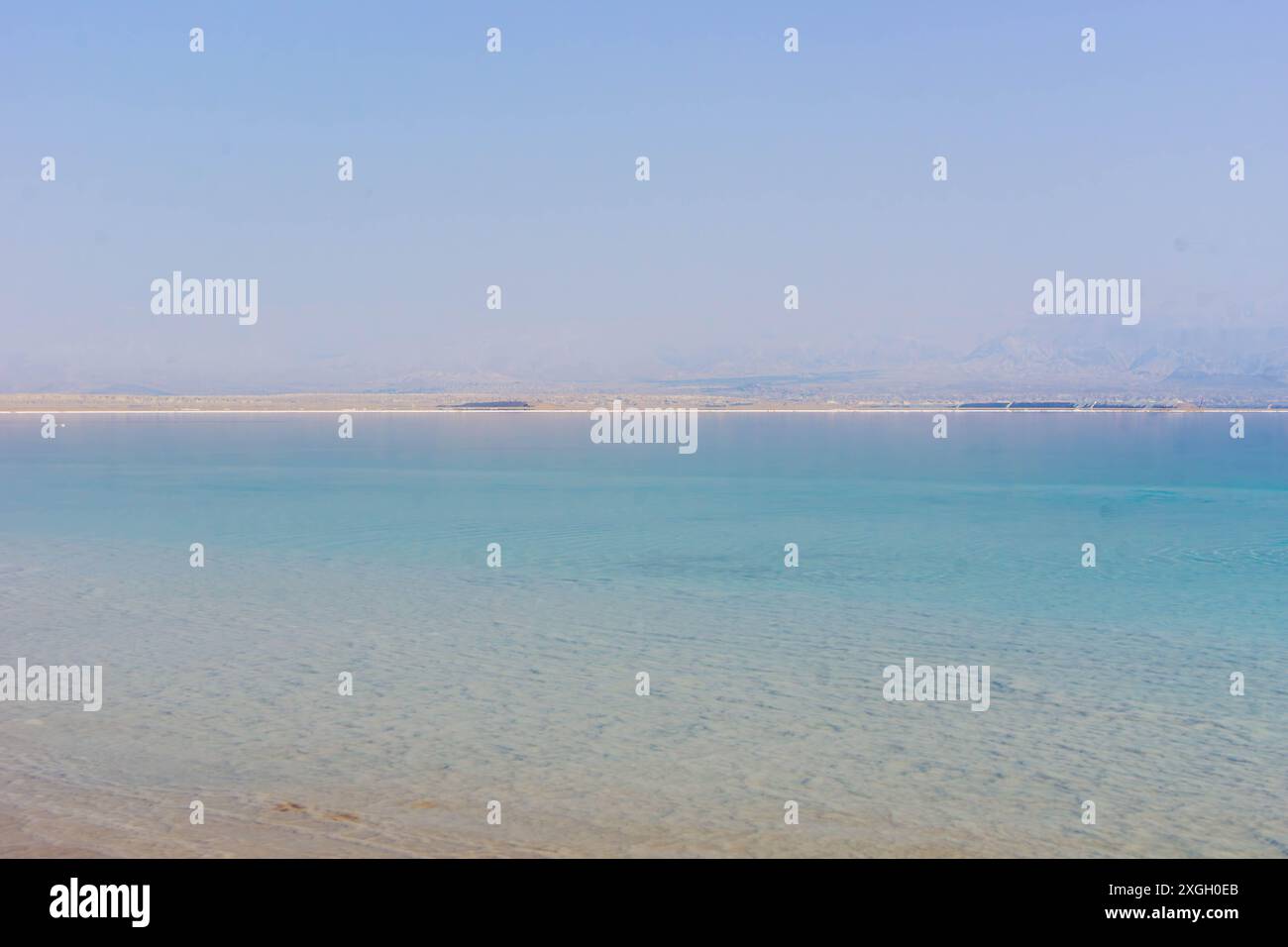 The azure turquoise water of the Dead Sea on the Ein Bokek beach resort during the hot summer ...