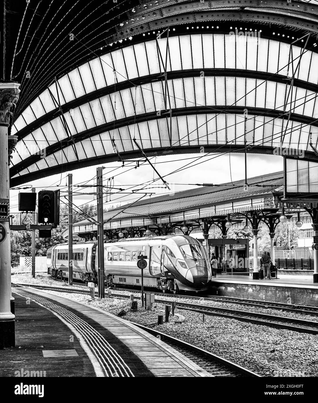 Historic curving arch covers a railway station platform and a train ...