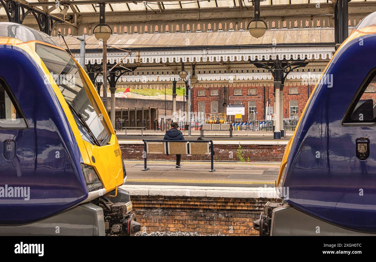 Two locomotives face each other at a railway station platform. In ...