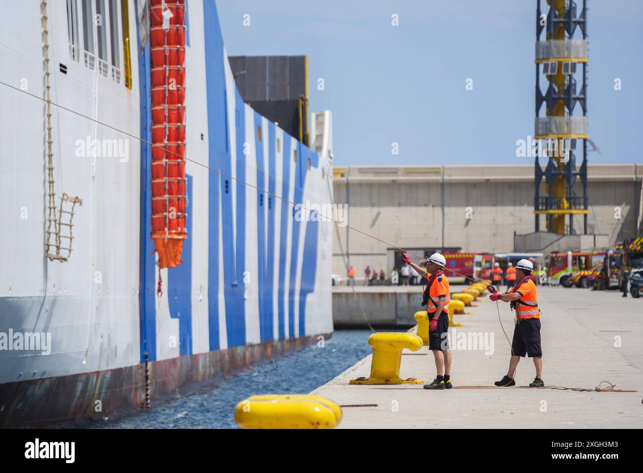 Workers prepare the arrival of the ship of the shipping company GNV ...