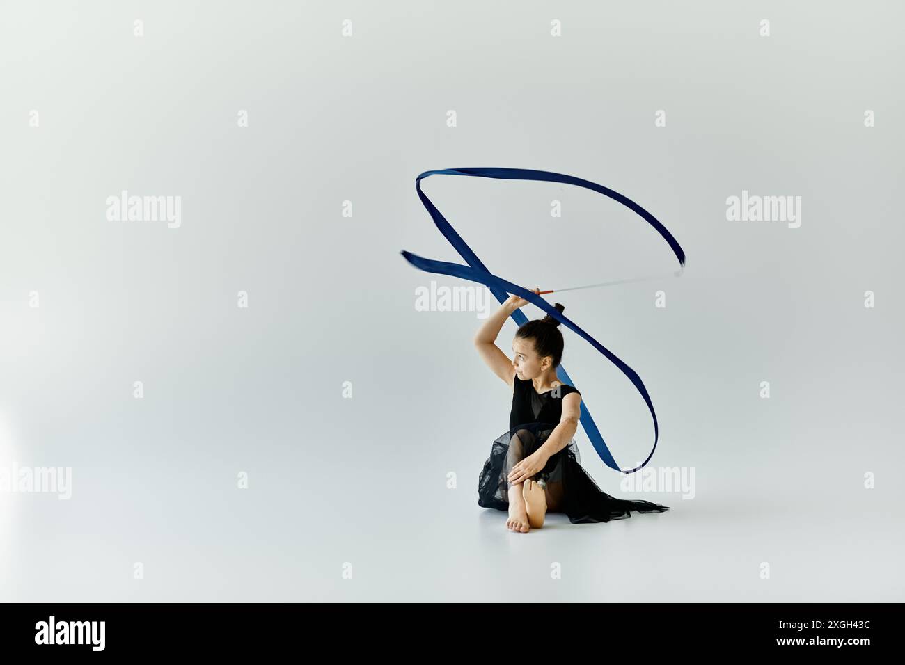 A young girl with a prosthetic leg performs a graceful ribbon routine ...