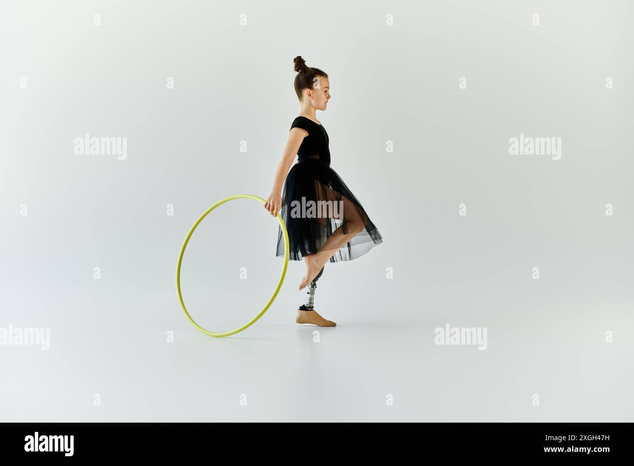 A young girl with a prosthetic leg gracefully performs a gymnastics ...