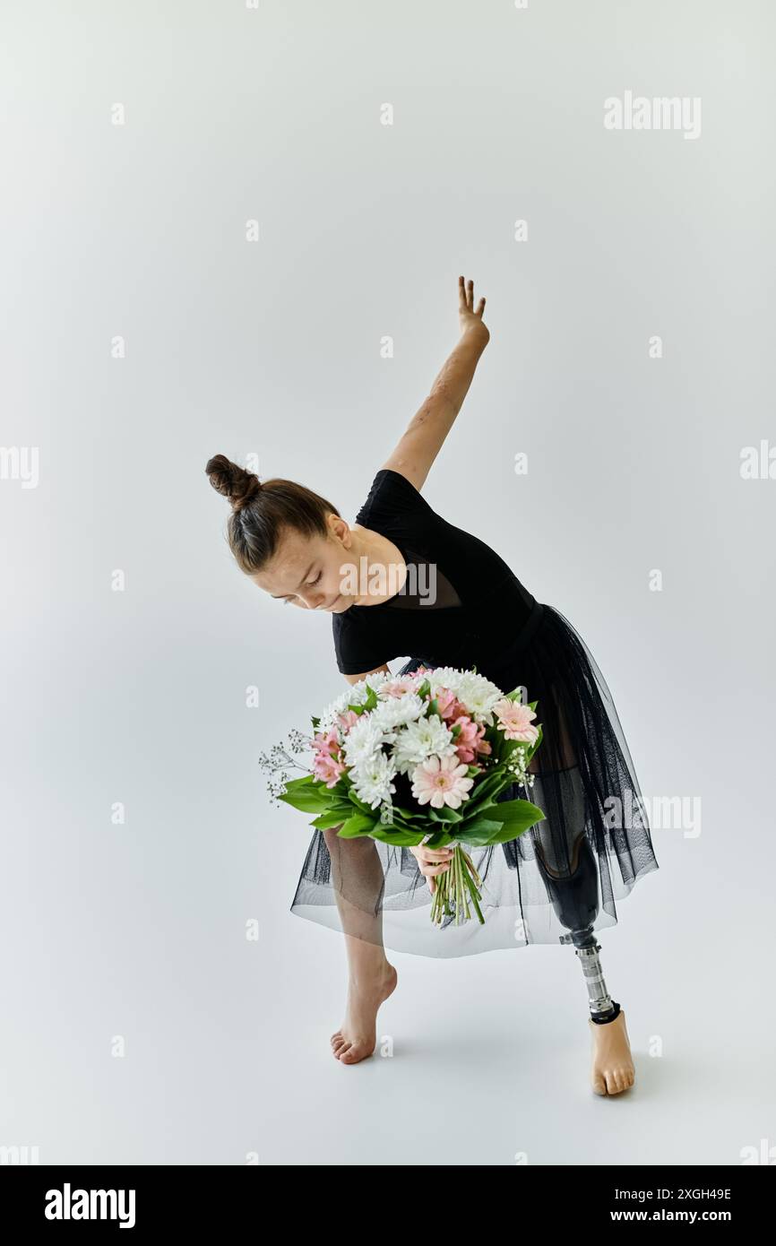 A young girl with a prosthetic leg performs a gymnastic pose while ...