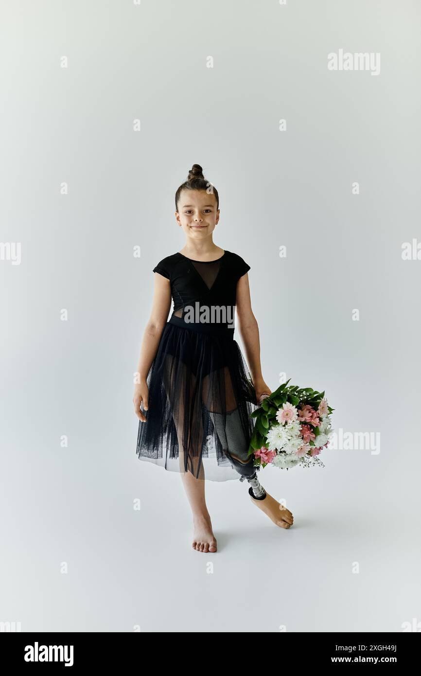 A young girl with a prosthetic leg poses with flowers while wearing a ...
