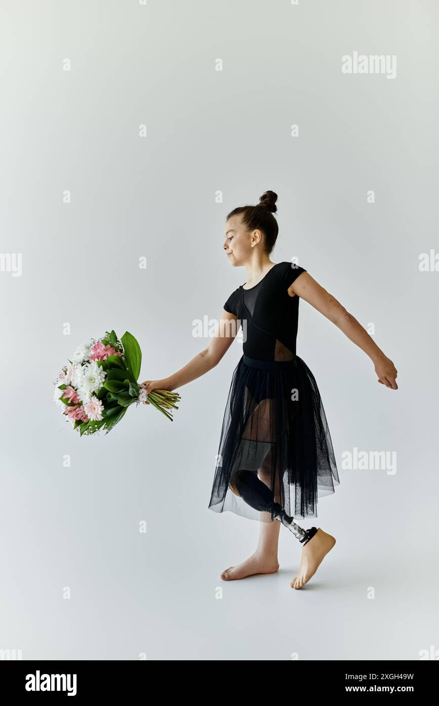 A young girl with a prosthetic leg gracefully dances with a bouquet of ...