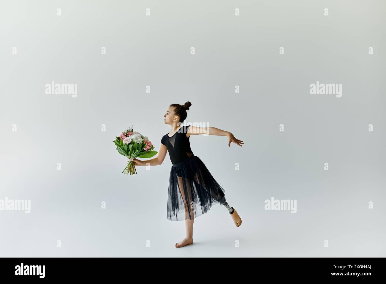 A young gymnast with a prosthetic leg performs a graceful pose while ...