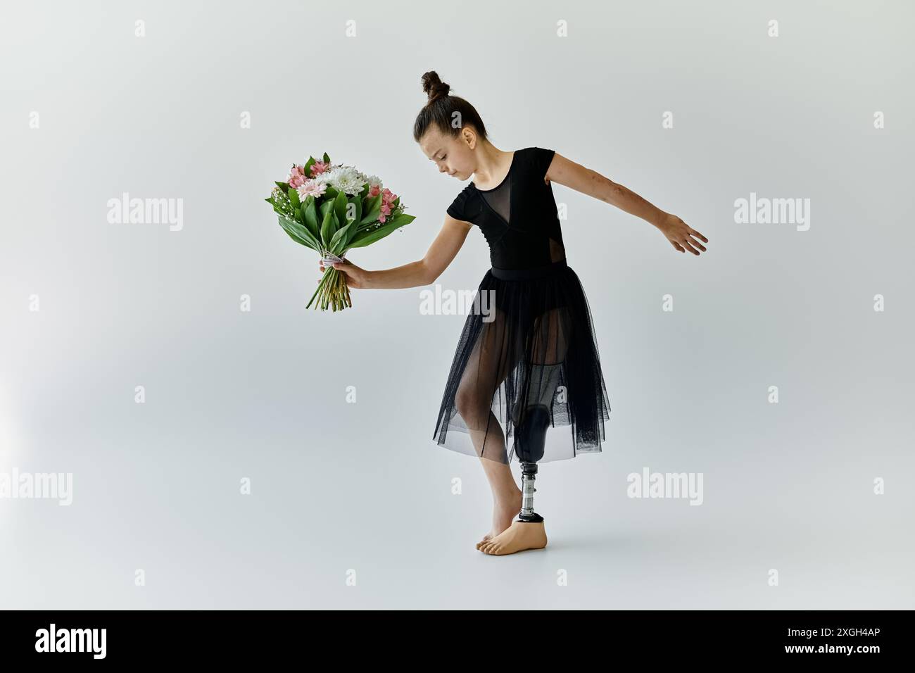 A young girl with a prosthetic leg poses gracefully with a bouquet of ...