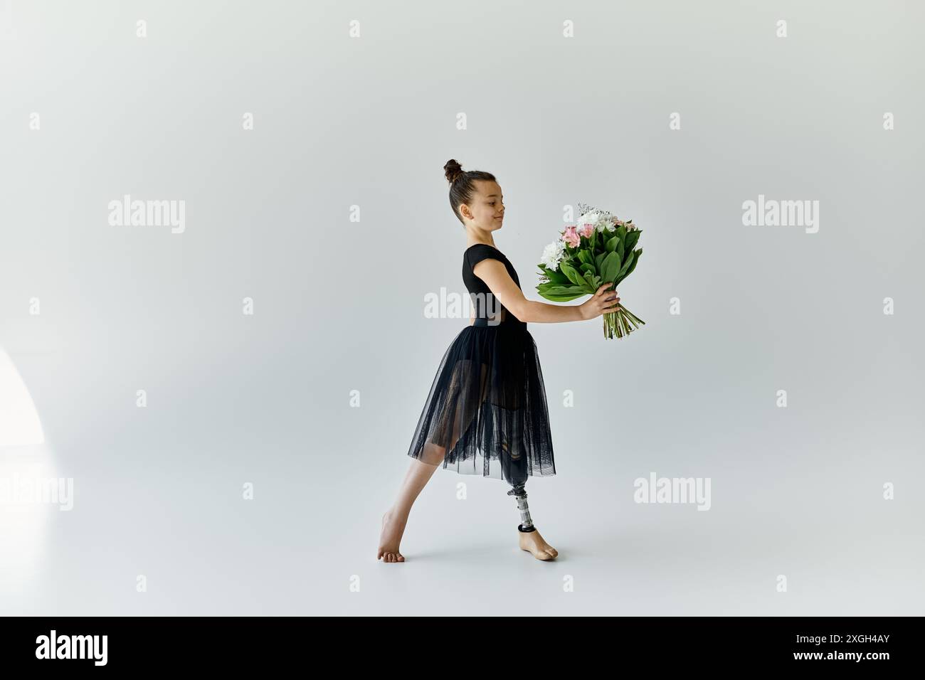 A young girl with a prosthetic leg gracefully holds a bouquet of ...