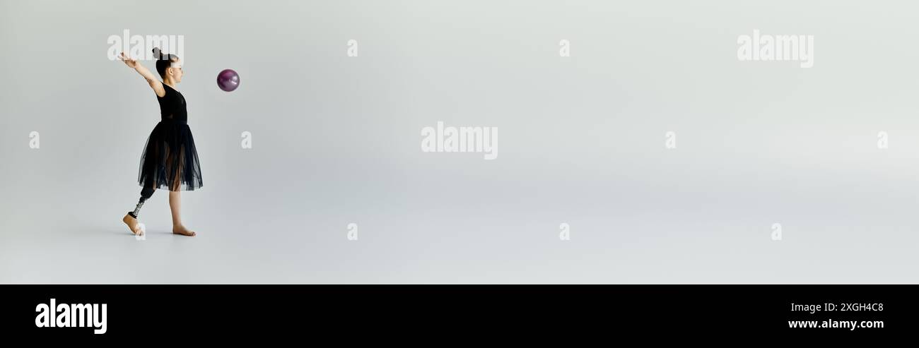 A young girl with a prosthetic leg throws a ball while performing ...