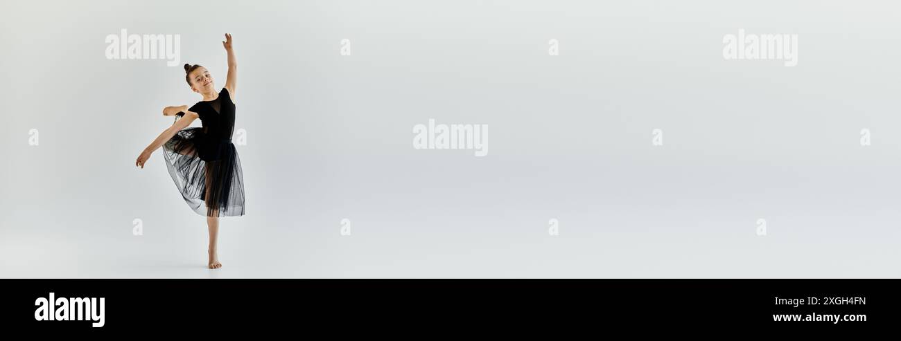 A young girl with a prosthetic leg performs a graceful ballet pose in a ...