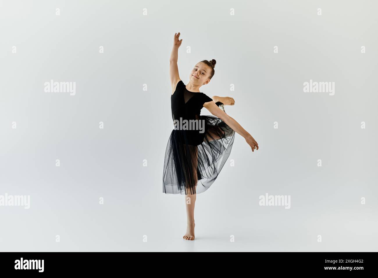 A young girl with a prosthetic leg demonstrates her talent in ballet by ...