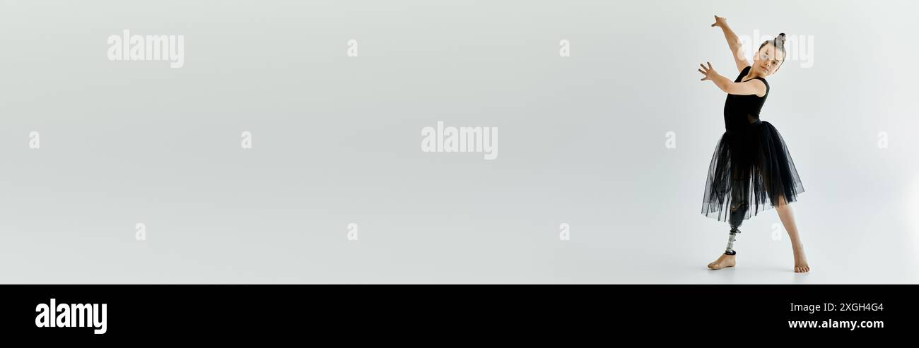 A young ballerina with a prosthetic leg performs a graceful pose in a ...