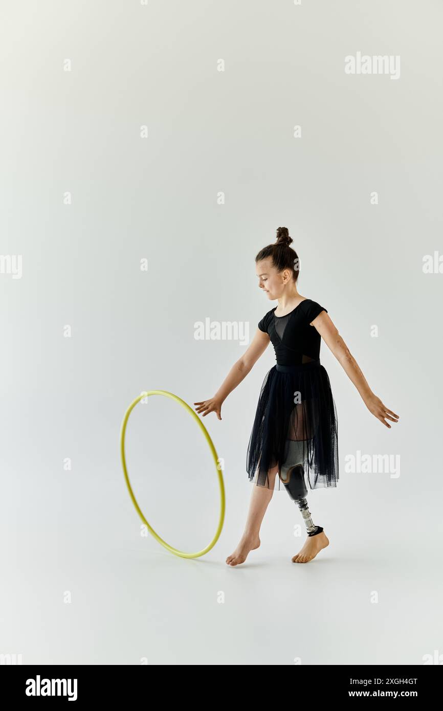 A young girl with a prosthetic leg performs a hula hoop routine in a ...