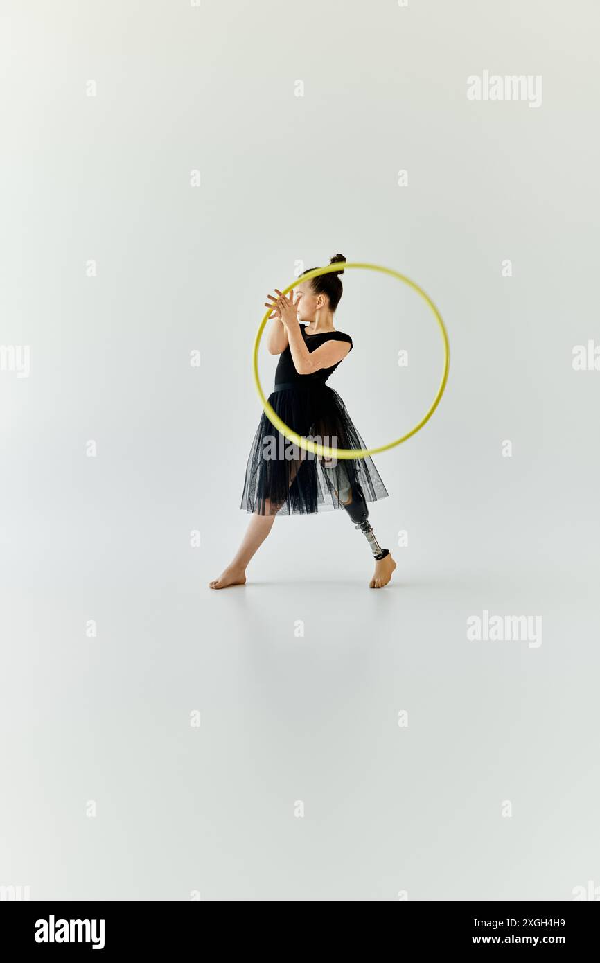 A young girl with a prosthetic leg performs gymnastics with a hula hoop ...