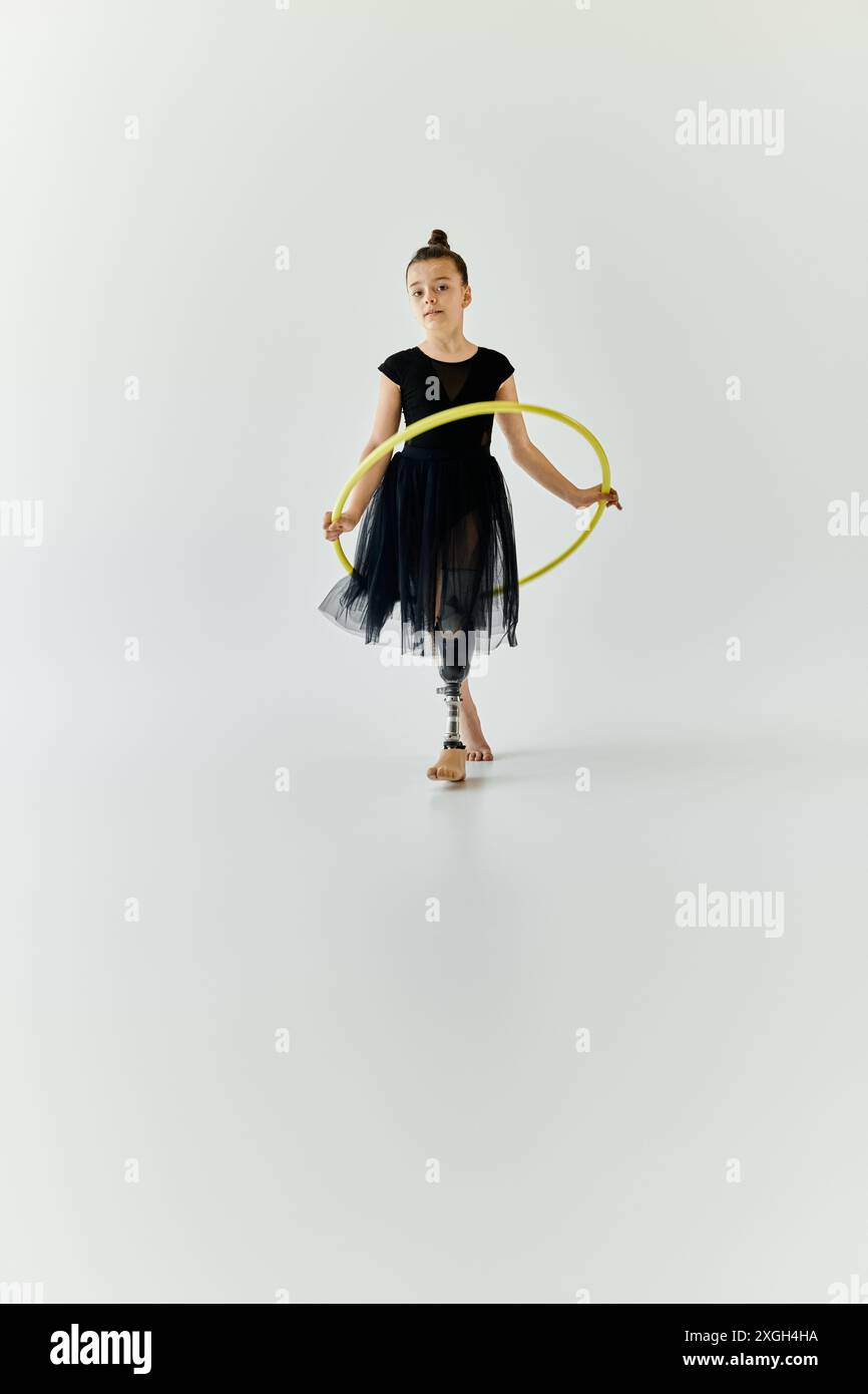A young girl with a prosthetic leg performs a hula hoop routine in a ...