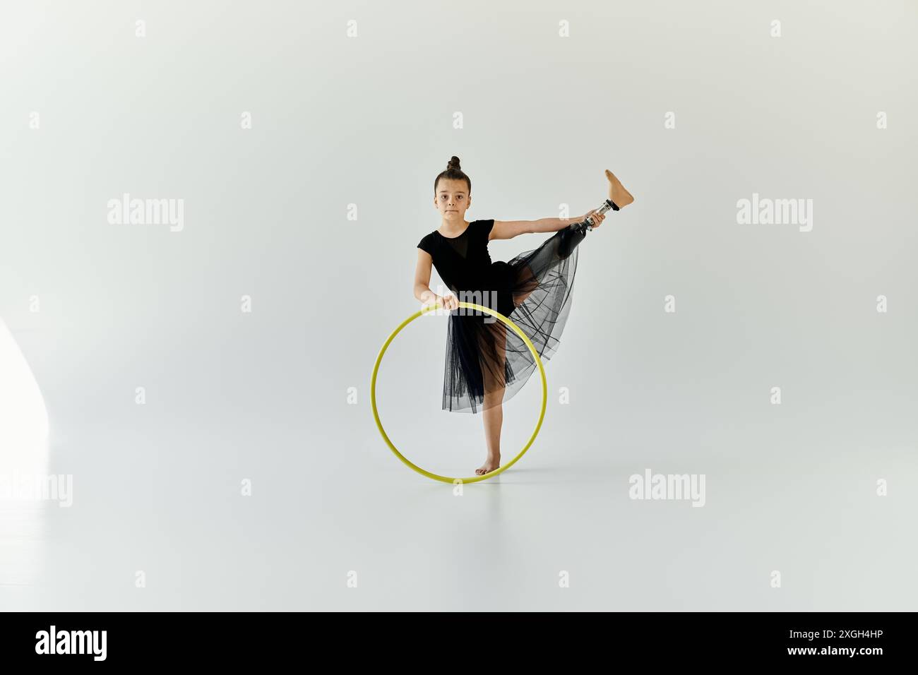 A young girl with a prosthetic leg performs a gymnastic pose with a ...