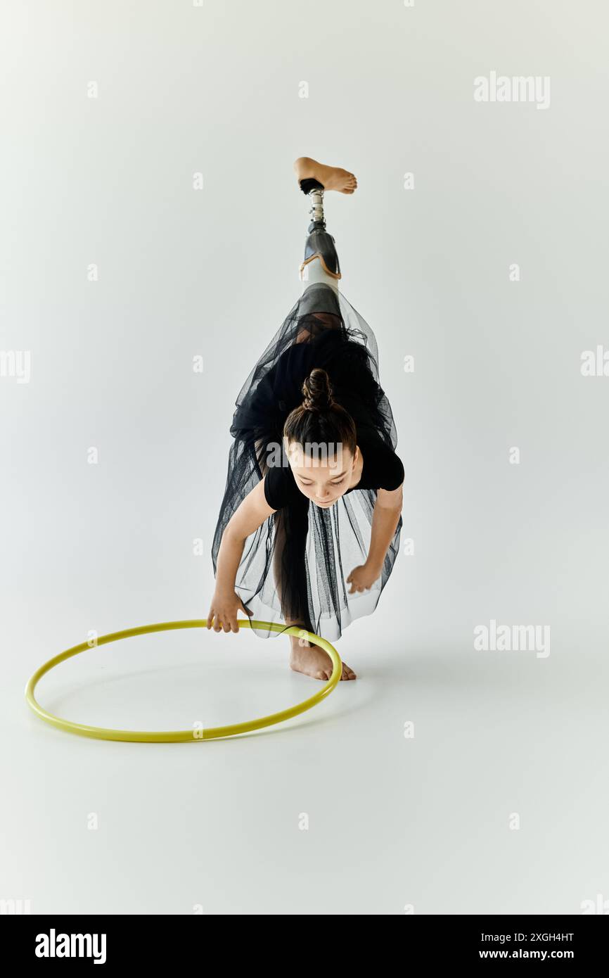 A young girl with a prosthetic leg practices her gymnastics routine ...