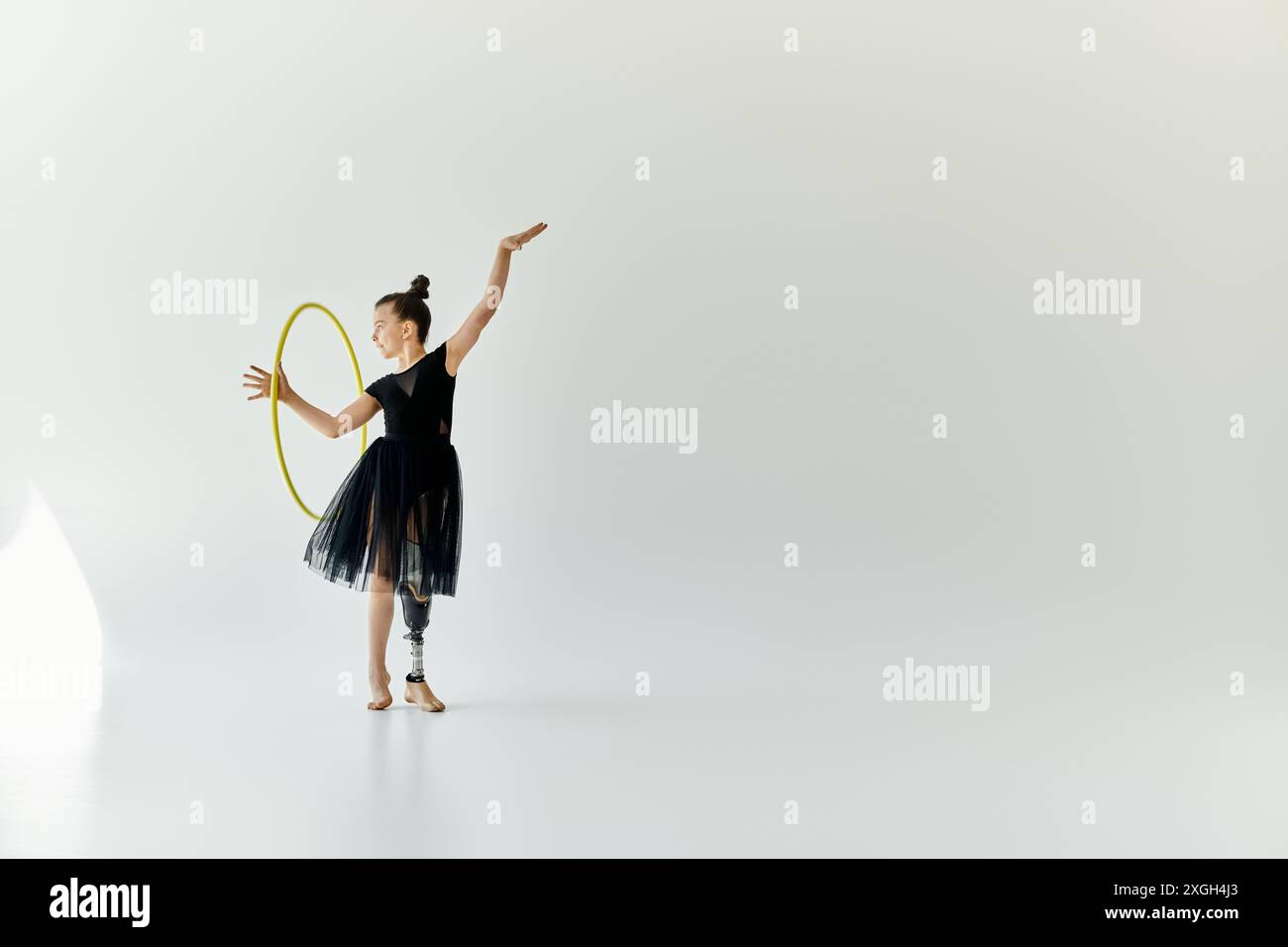 A young gymnast with a prosthetic leg performs a graceful hoop routine ...