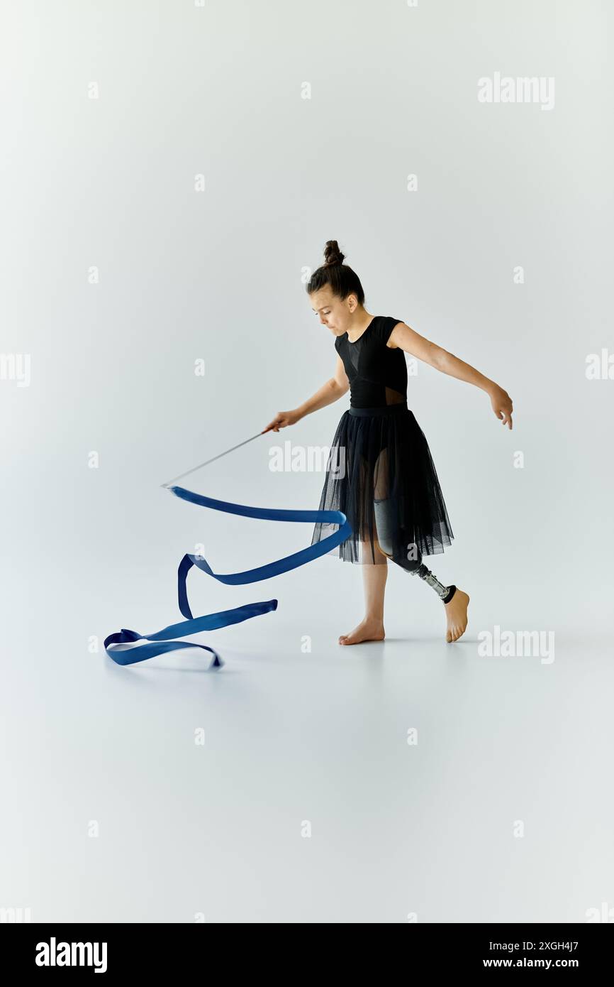 A young girl with a prosthetic leg performs gymnastics with a blue ...