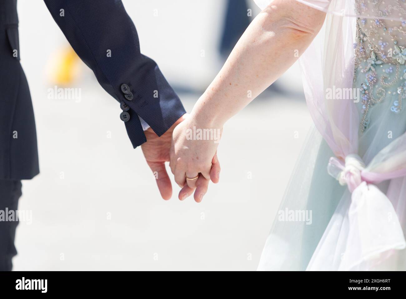 Close-up of a couple holding hands, symbolizing love and unity on their ...