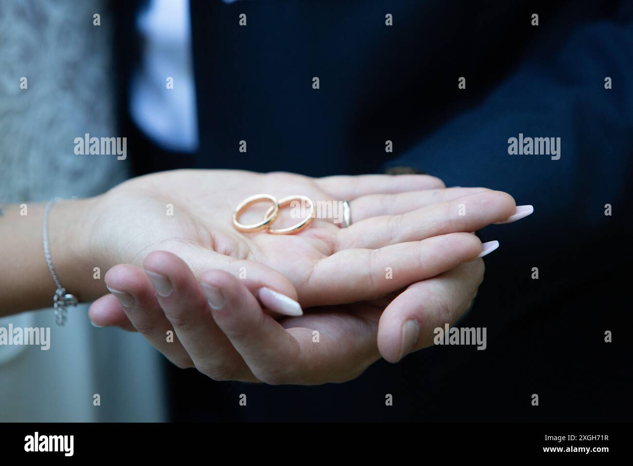 Bride and groom holding wedding rings, symbolizing commitment and love ...