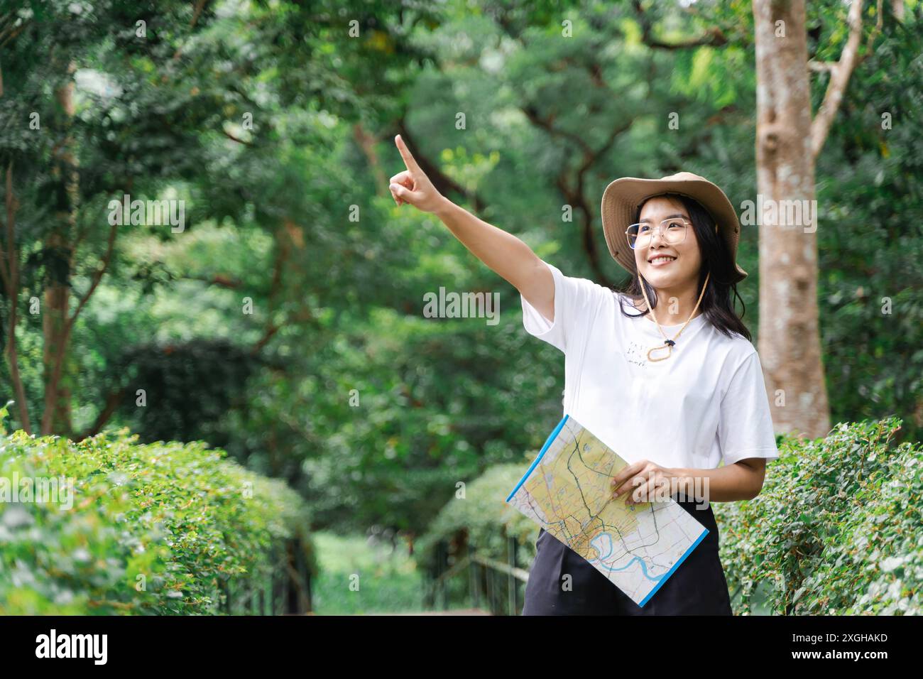 Asian woman explorer hold paper map to survey natural route , point ...