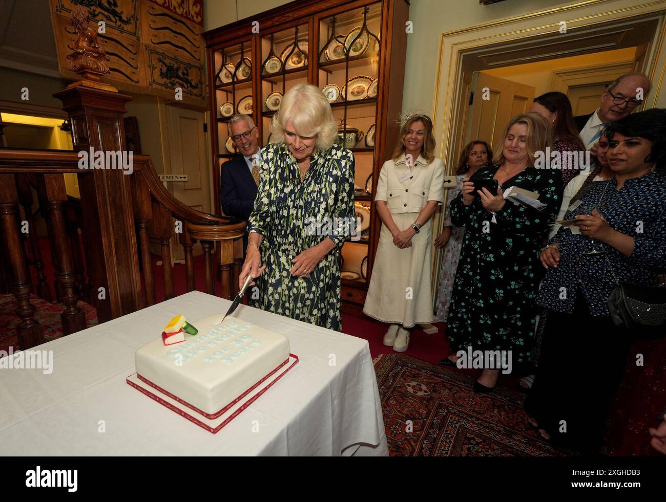 Queen Camilla cuts a cake to celebrate the National Literacy Trust ...