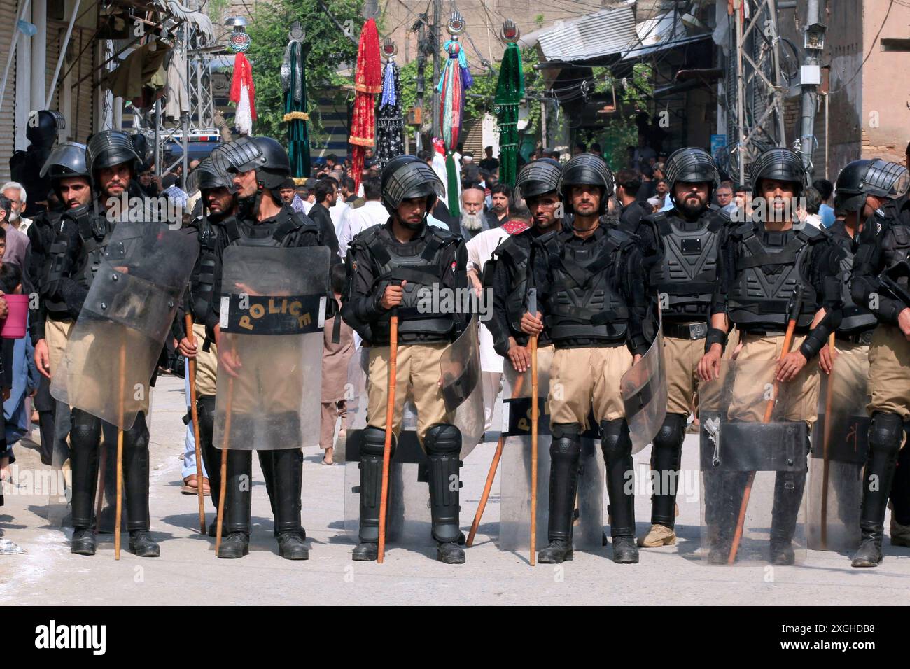 Police officers with riot gear move ahead of Shiite Muslims to ensure ...
