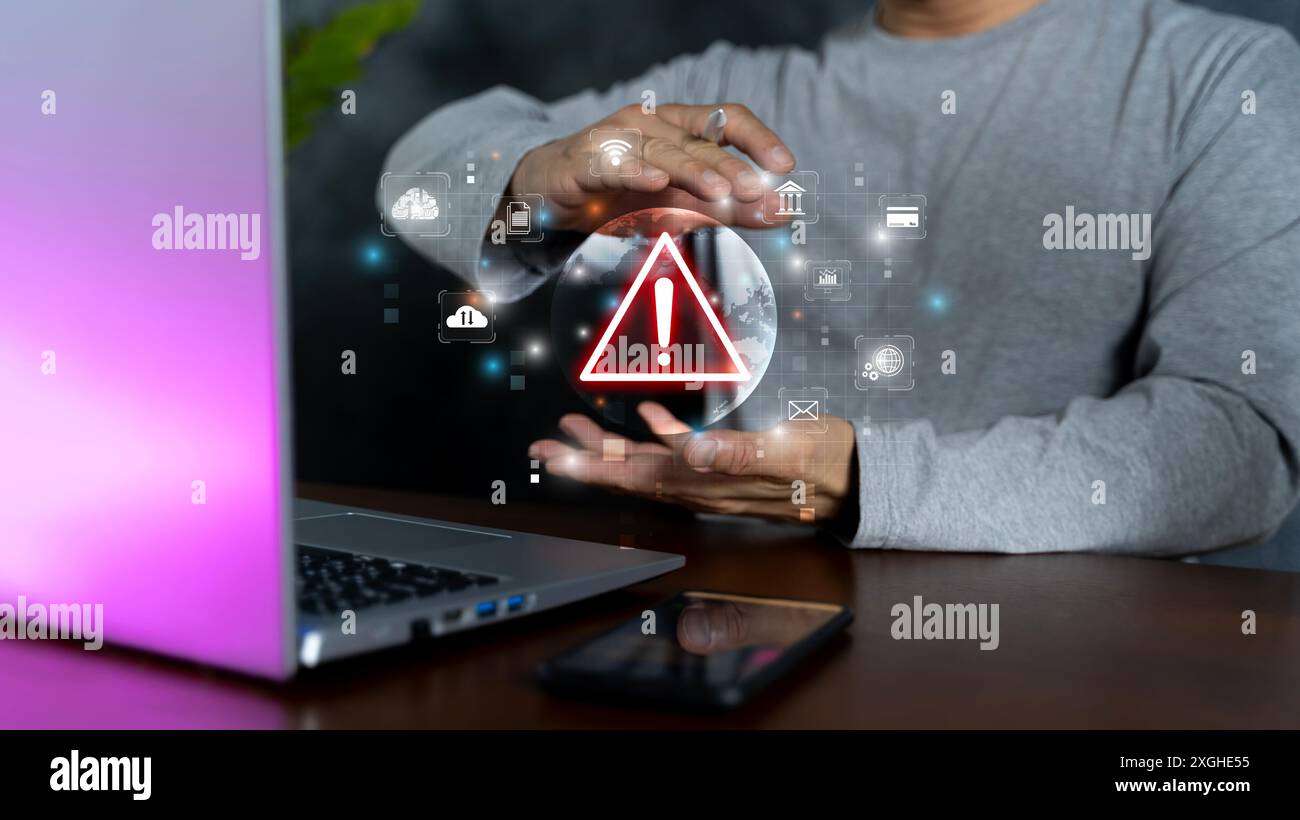 Young business man hand using smartphone, laptop with warning sign for ...
