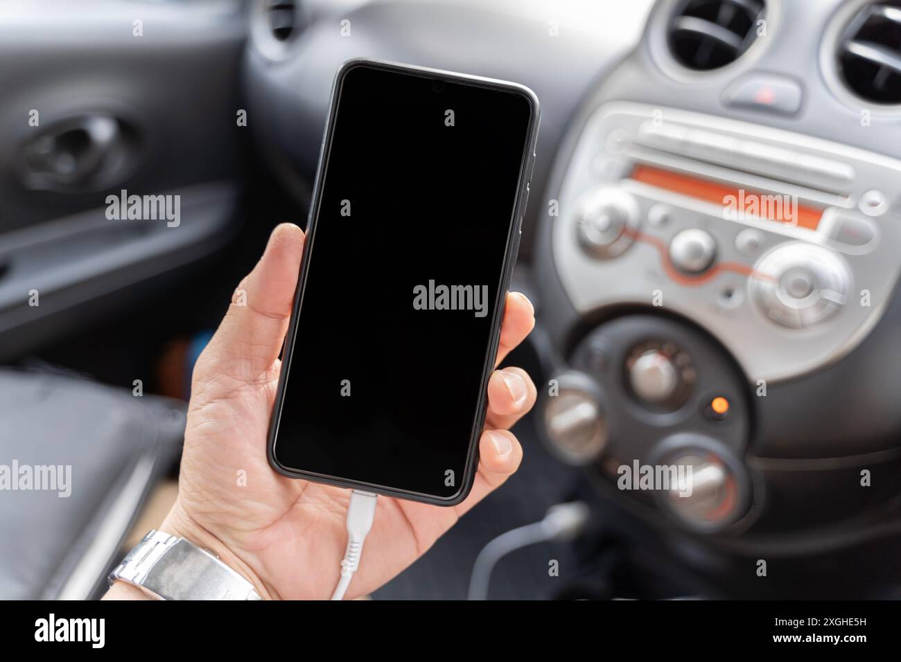 Young man using smart phone mobile phone in car. Close up view. Close ...